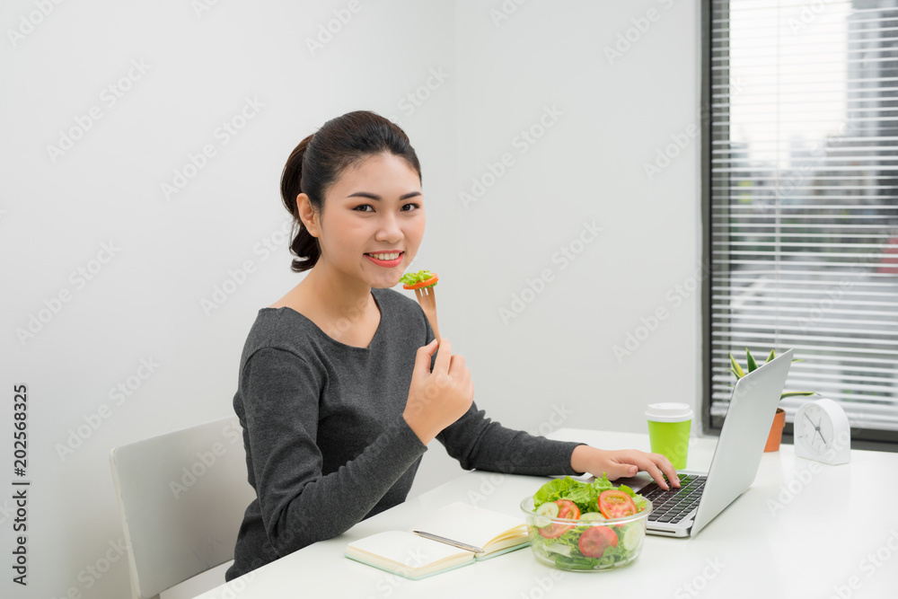 Woman has healthy business lunch in modern office interior. Young ...
