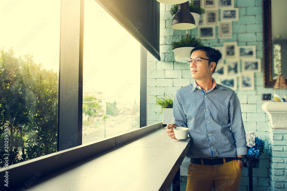 Young Asian happy man look through clear window and thinking during ...