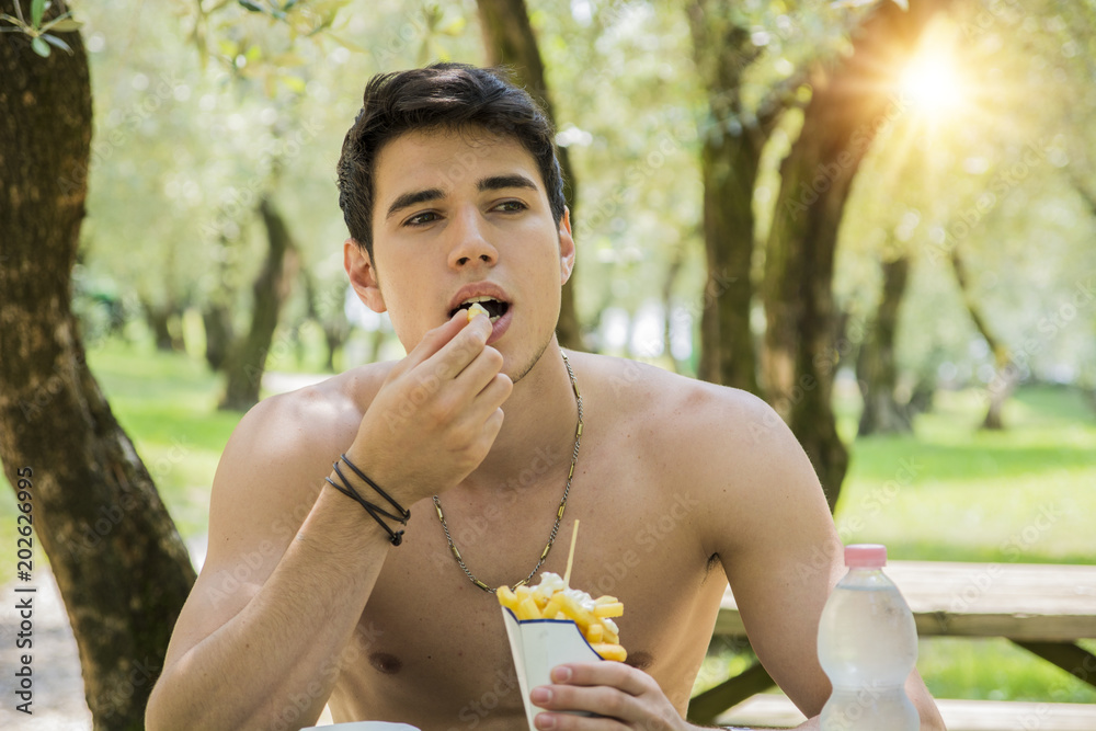 Portrait of Young Muscular Man Sitting Shirtless in Park at Picnic ...