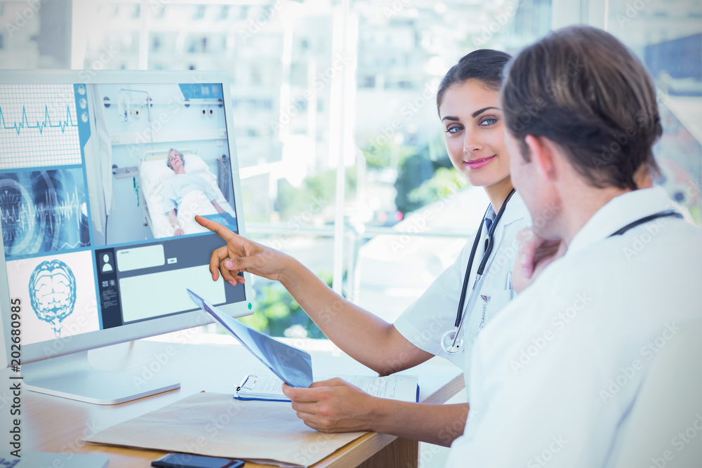Doctor showing the screen of a computer to a colleague against white ...