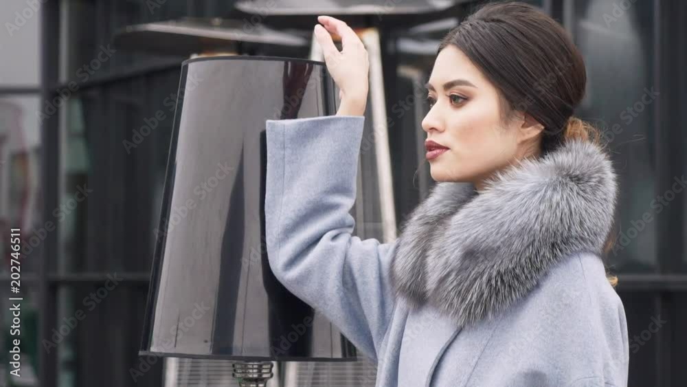 Street photo shoot of a girl in a coat. Photoshoot for the catalog of a ...