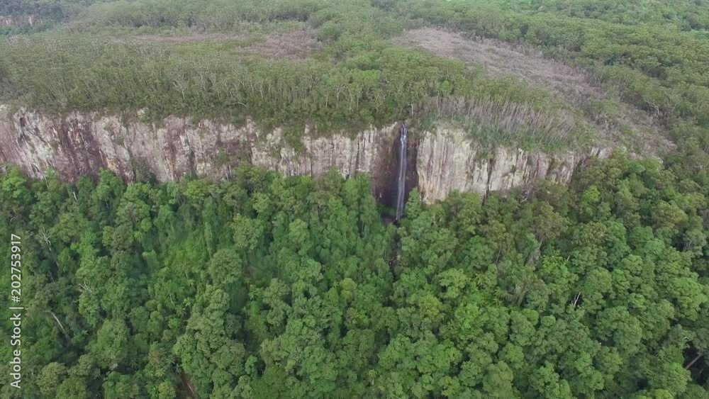 Aerial pan across tall waterfall and rugged cliff in Gondwana ...