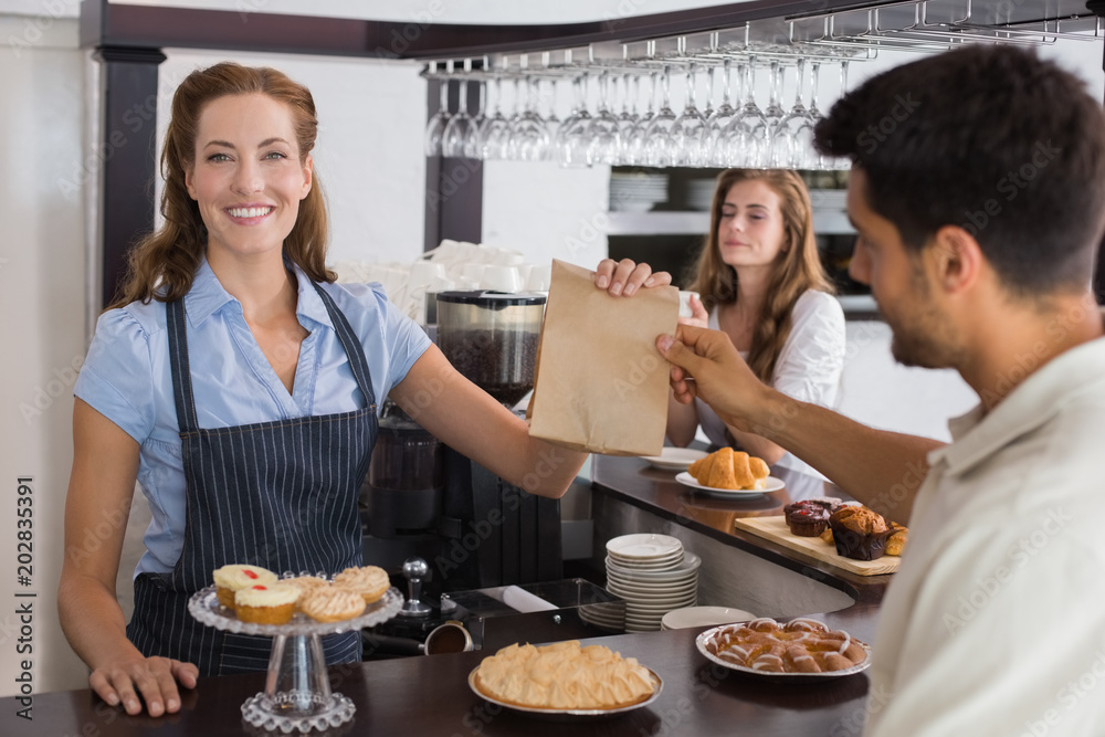Cafe owner giving packed food to a couple at coffee shop Stock Photo ...