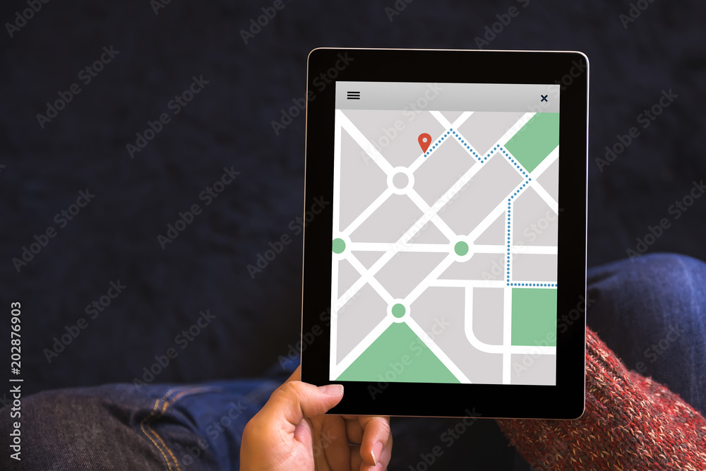 Hands holding digital tablet computer with location tracker concept on ...