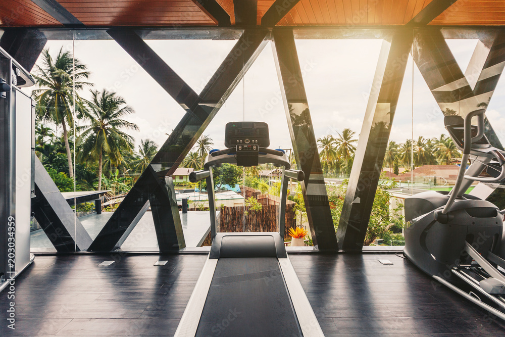 Small gym in Luxury villa, big window, tropical view with palm trees ...