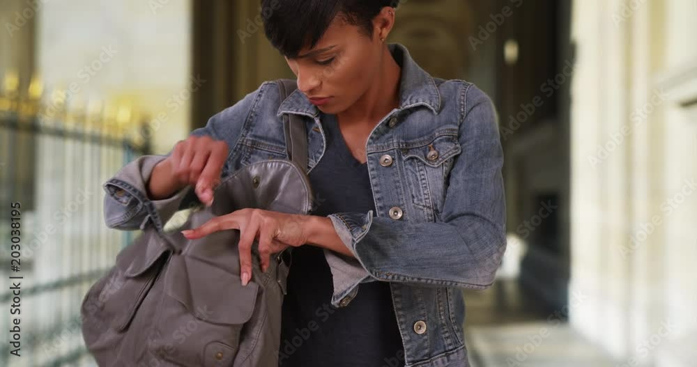 Vidéo Stock Young black woman looks through her purse for something ...