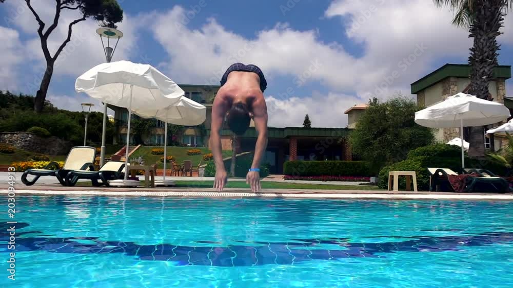 Man is jumping into pool. Young man shows off underwater a like ...