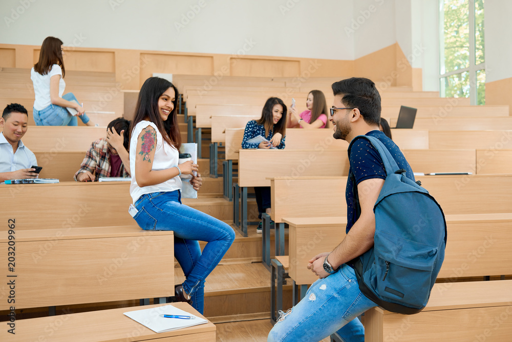 Backview of students talkingin university in front of groupmates ...