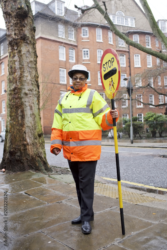 Portrait of crossing guard holding stop sign Stock Photo | Adobe Stock