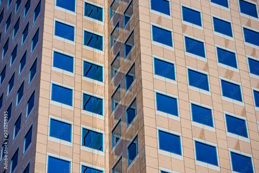Dozens of windows form the angled facade of a modern skyscraper ...