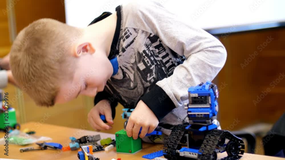 the boy of 10 years, plays in the designer from cubes, plates, circuits ...