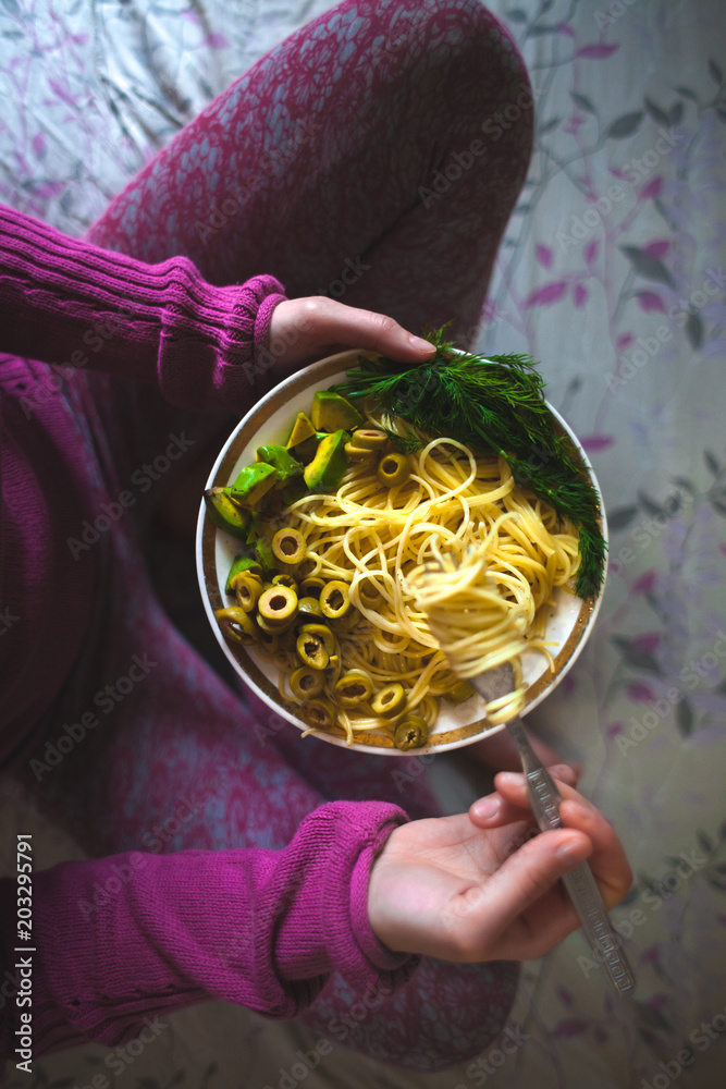 A woman is eating pasta. Stock Photo | Adobe Stock