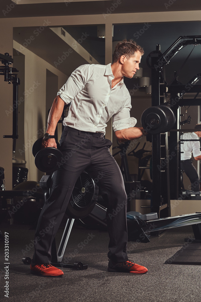 Handsome muscular businessman in formal clothes doing exercise with ...