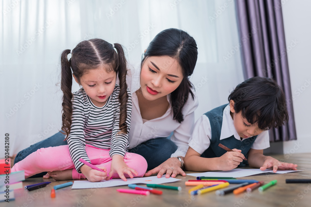 Mom teaching children in drawing class. Daughter and son painting with ...