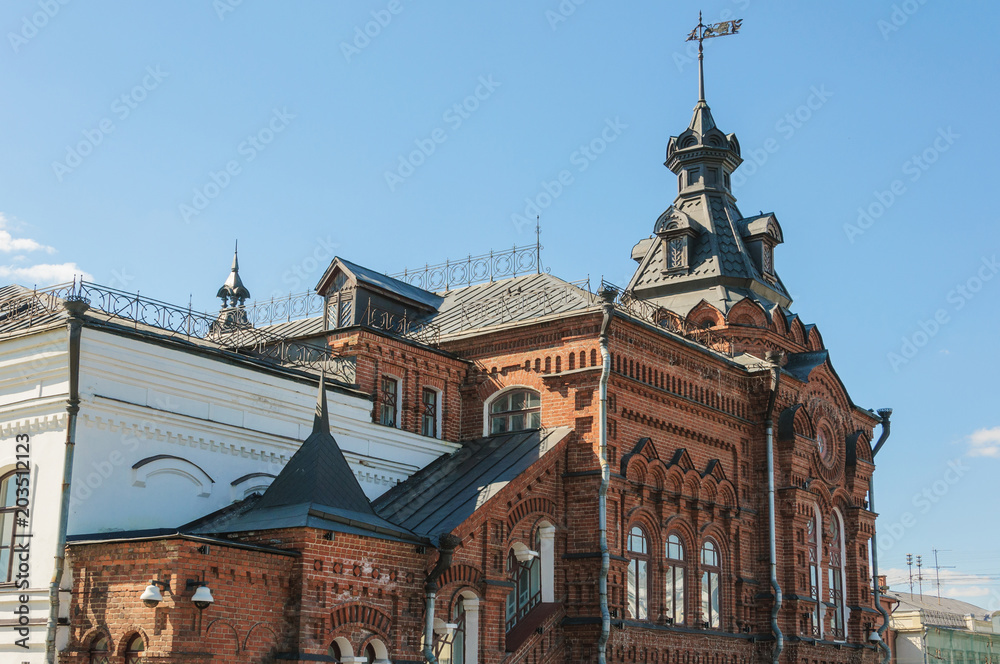 the old building with an arched porch and a tower of red brick ...