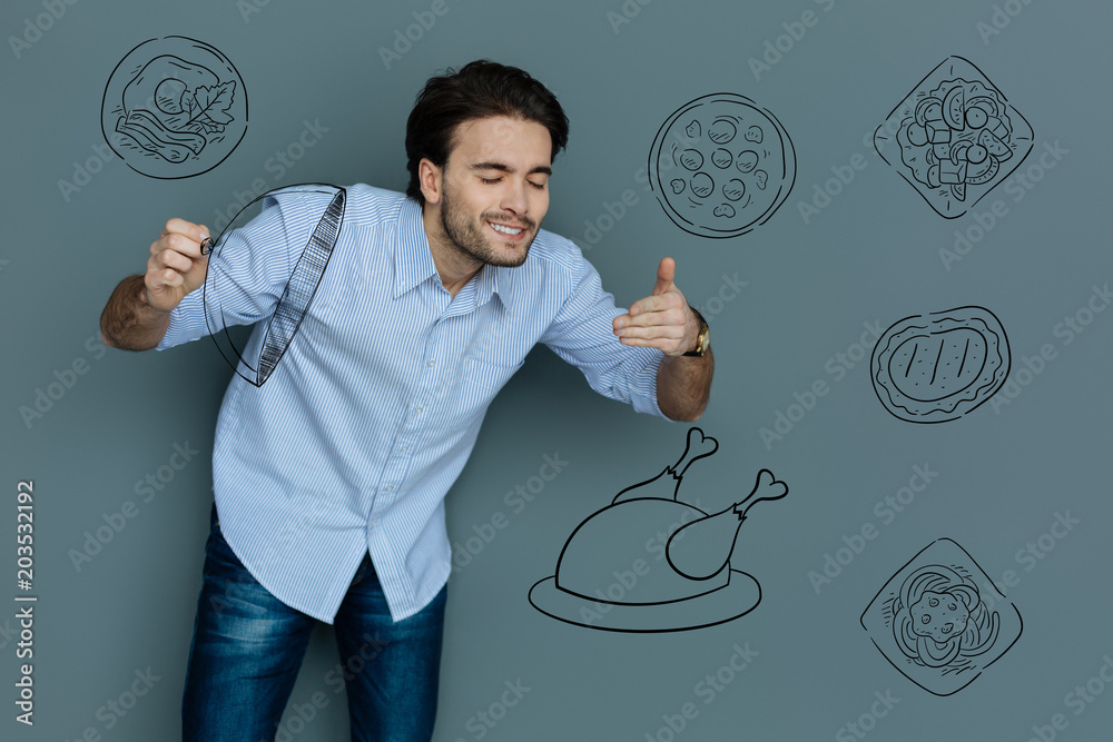 Amazing smell. Young experienced cheerful cook smiling and standing ...