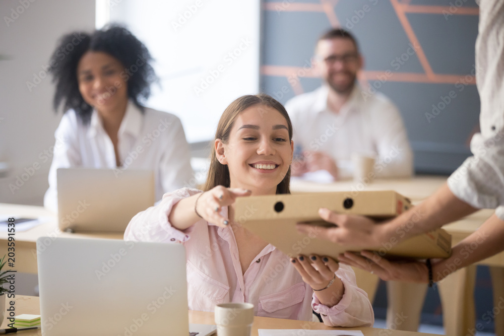 Delivery man giving pizza box to smiling female office worker ordered ...