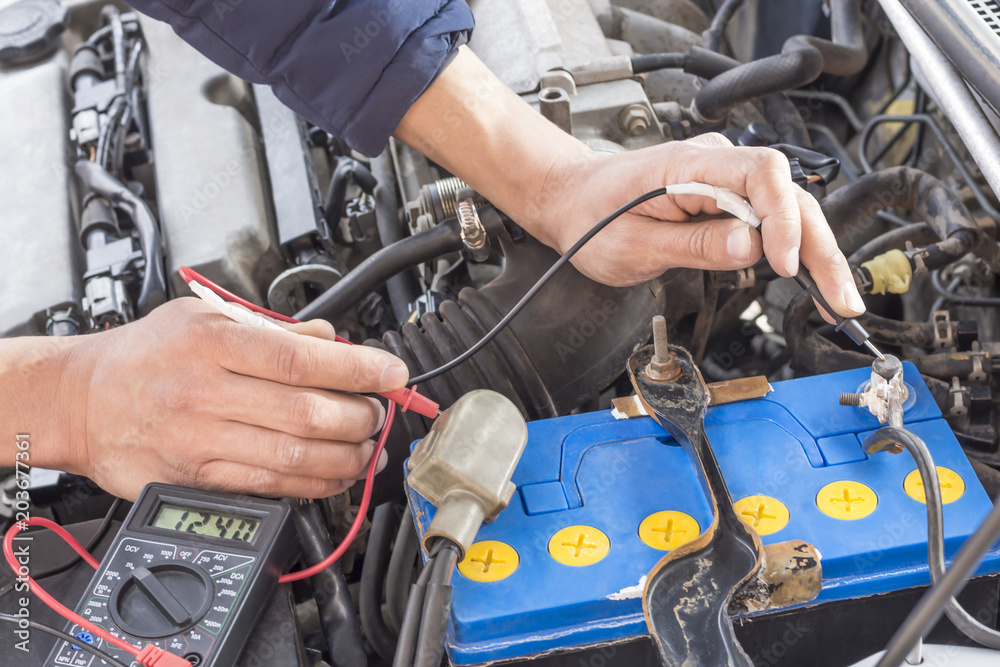 auto mechanic use digital multimeter check voltage battery and check ...