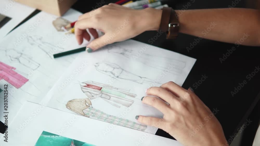 designer of clothes makes an outline of clothes with a felt-tip pen ...