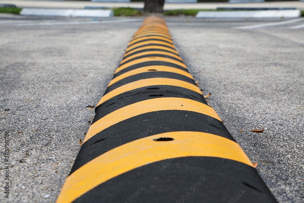 Yellow and Black Striped Speed Bump with Nails Visible in Parking Lot ...
