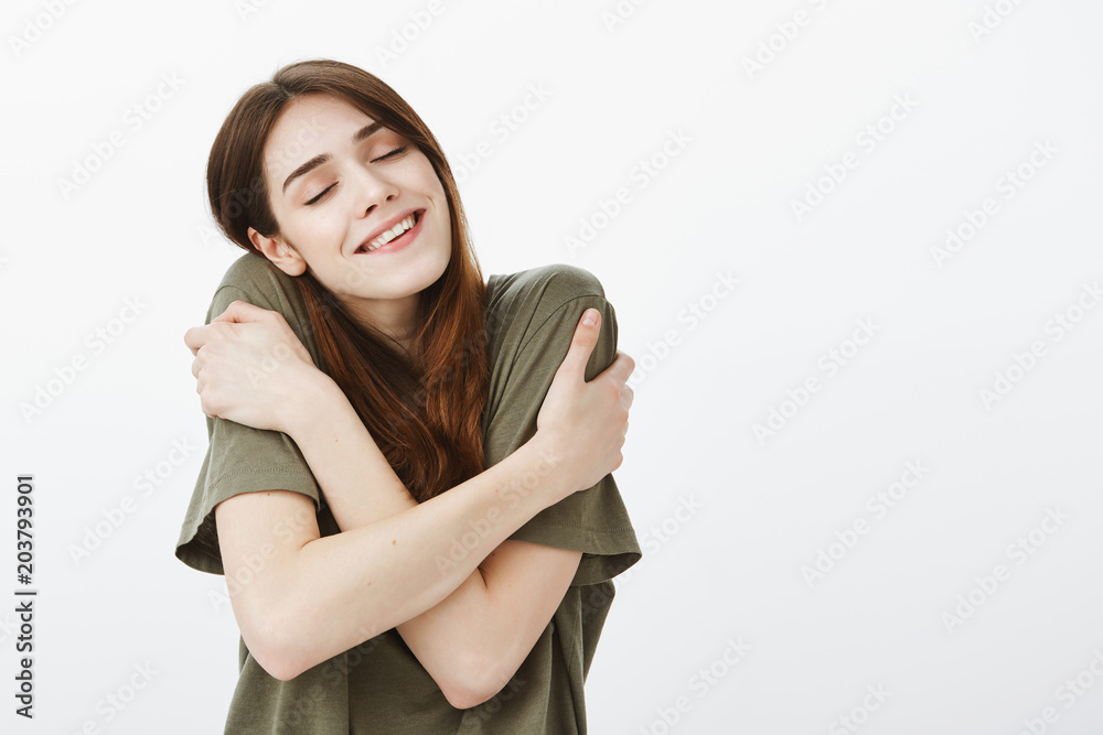 Creative happy woman dreaming to hug filmstar she likes. Shot of tender ...