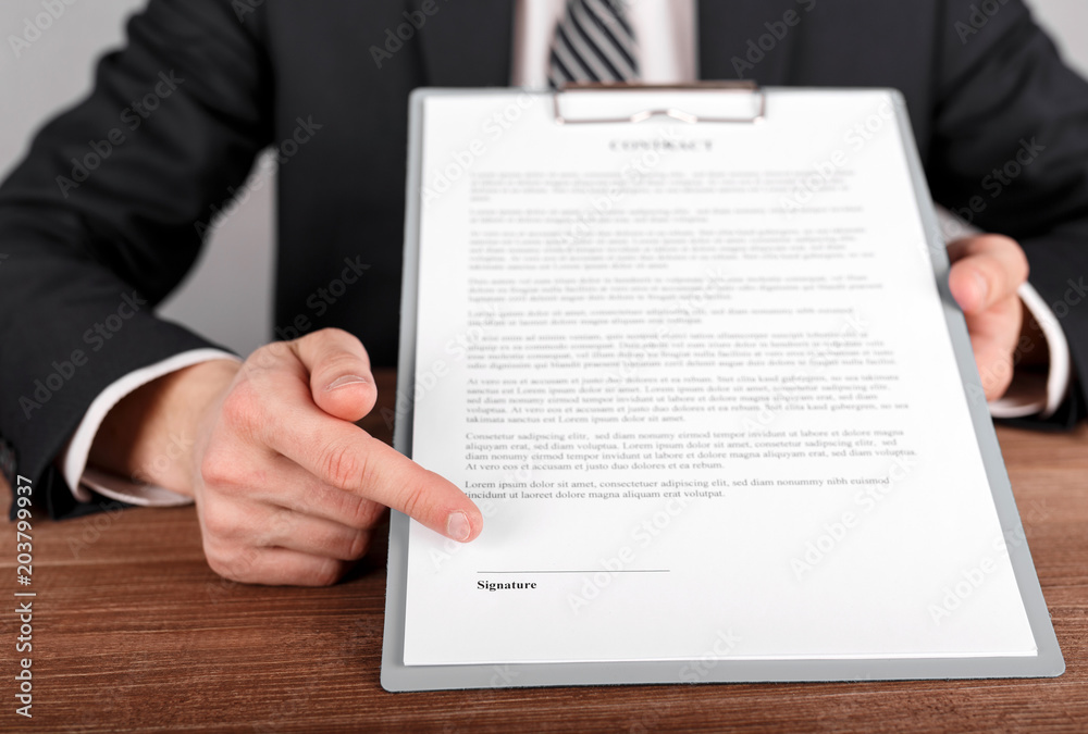 Businessman indicates the place for signing in the contract,which is ...