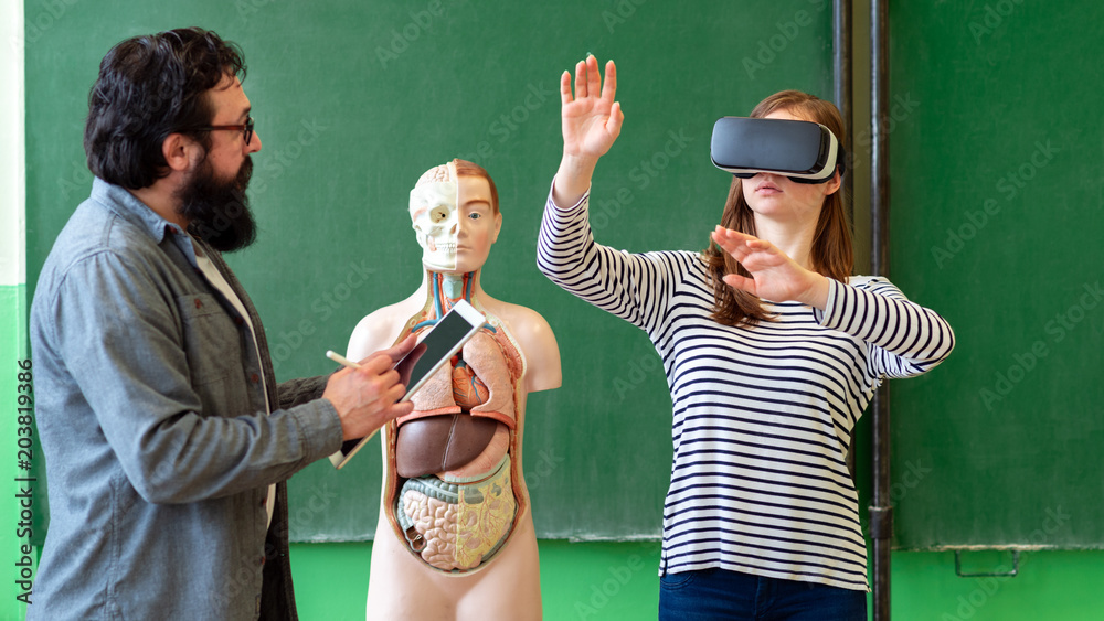 Young teacher using Virtual Reality Glasses and 3D presentation to ...