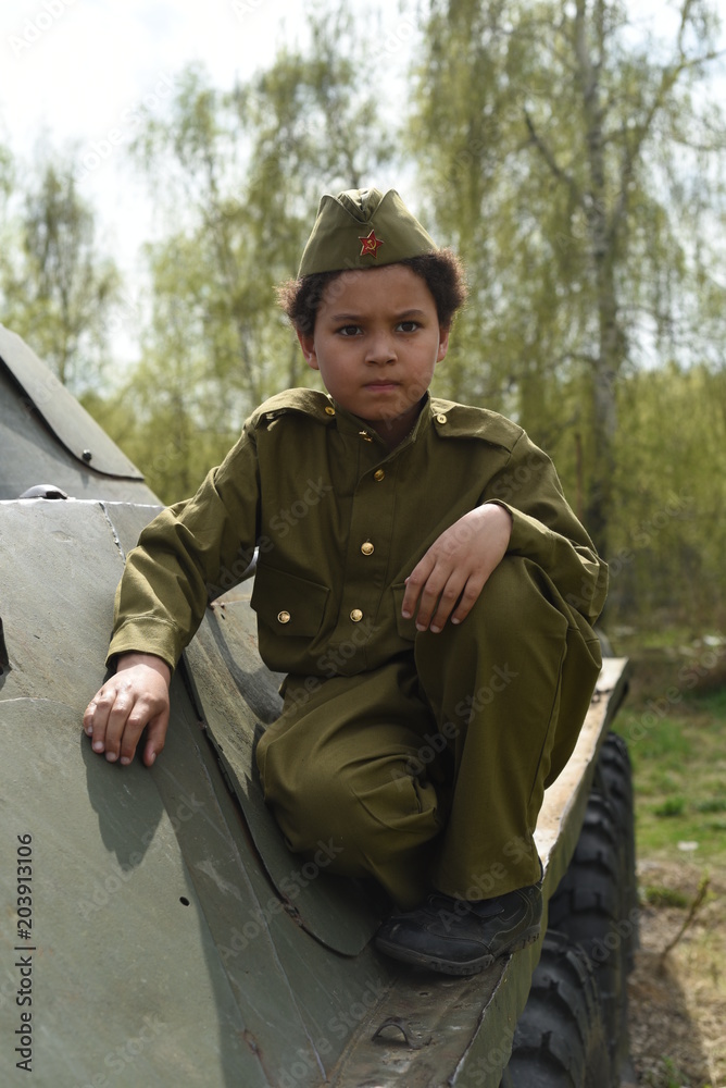 Boy in the military uniform on the tank of time of Second World War ...