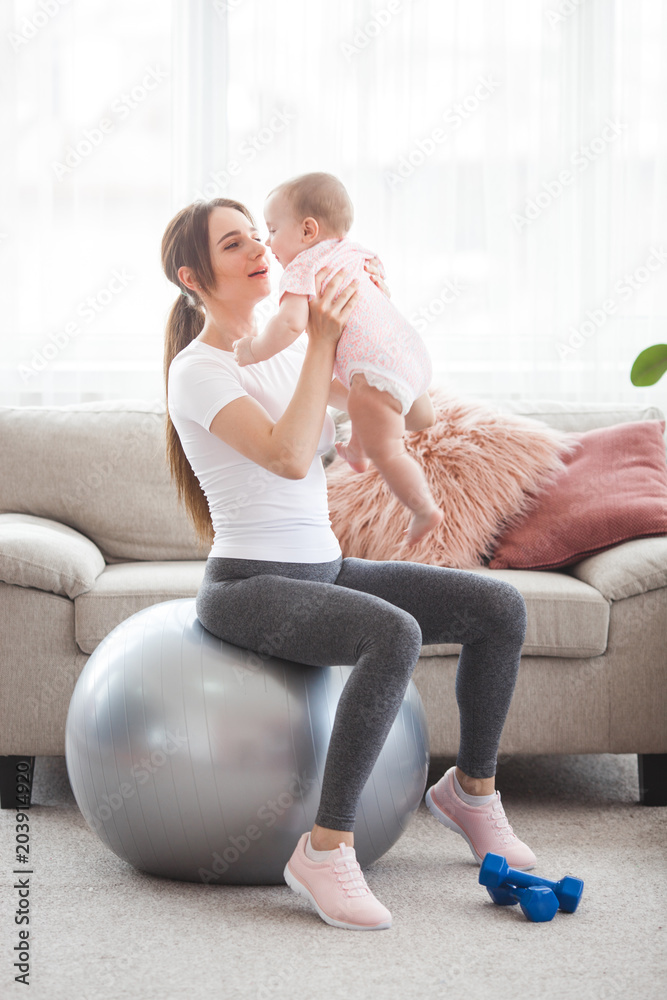 Young pretty mother working out with her little child at home Stock ...