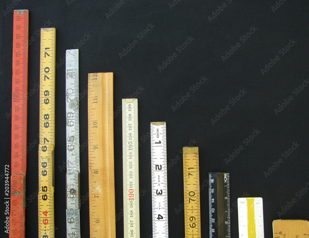 Rulers and scales in metric and inches descend along a chart or graph ...