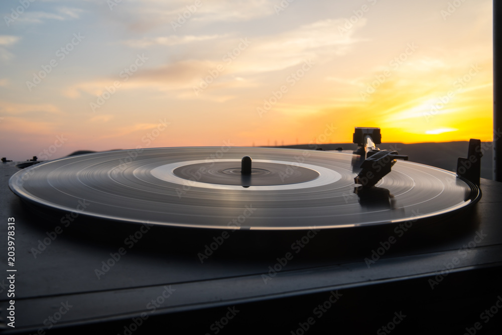 Foto Stock Turntable vinyl record player on the background of a sunset ...