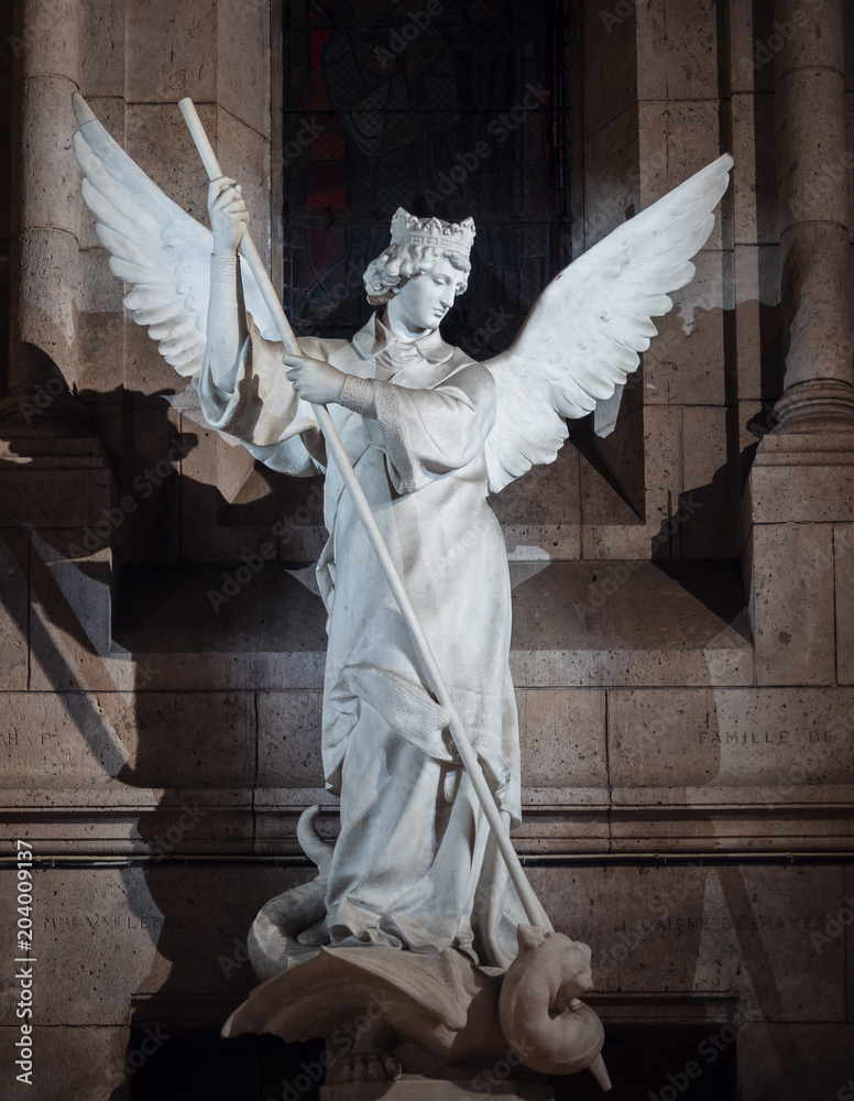 Statue of an angel in white stone inside the Basilica of the Sacred ...