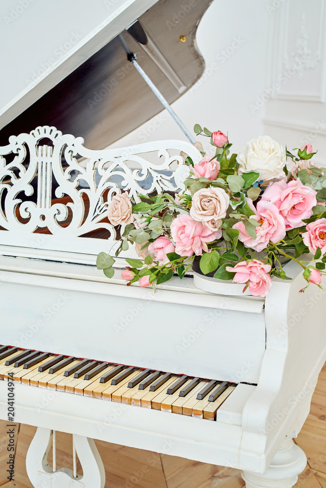 White grand piano with rose flowers in white classic interior, copy ...