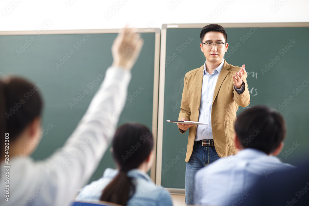 Teacher teaching students in a classroom Stock Photo | Adobe Stock
