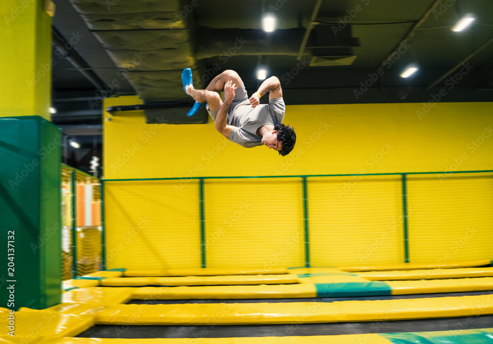 trampoline jumper performs complex acrobatic exercises and somersault ...