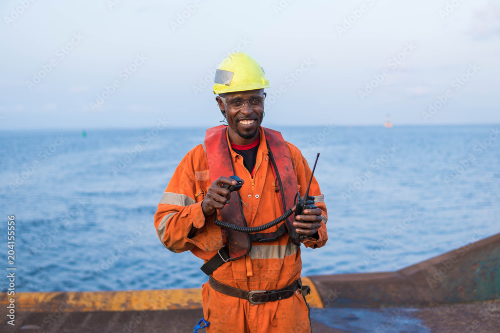 Seaman AB or Bosun on deck of vessel or ship , wearing PPE personal ...