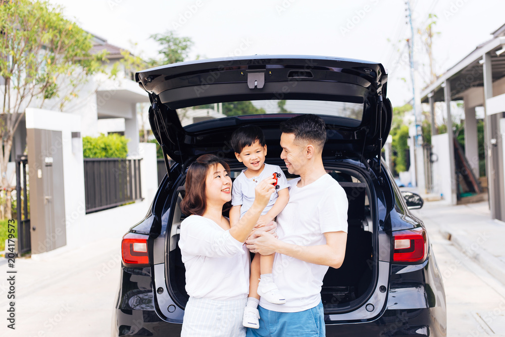 Happy Asian family standing on the back of SUV car with smile and ...