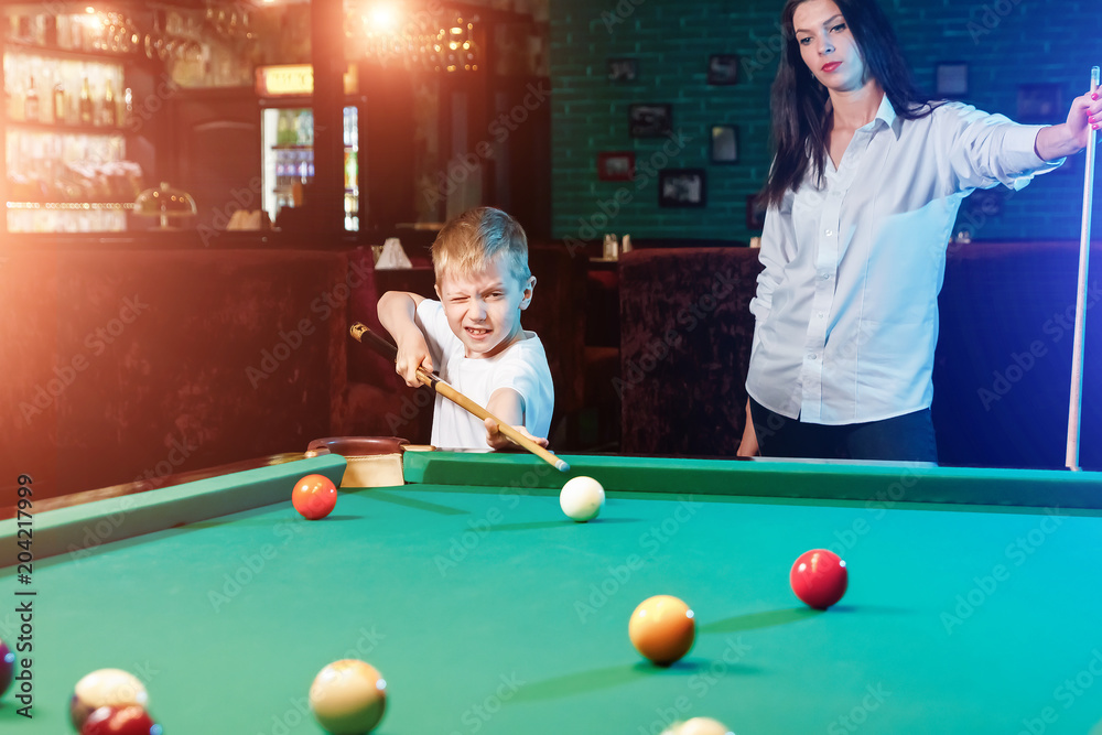 Father and son play billiards. The father teaches his son to play ...
