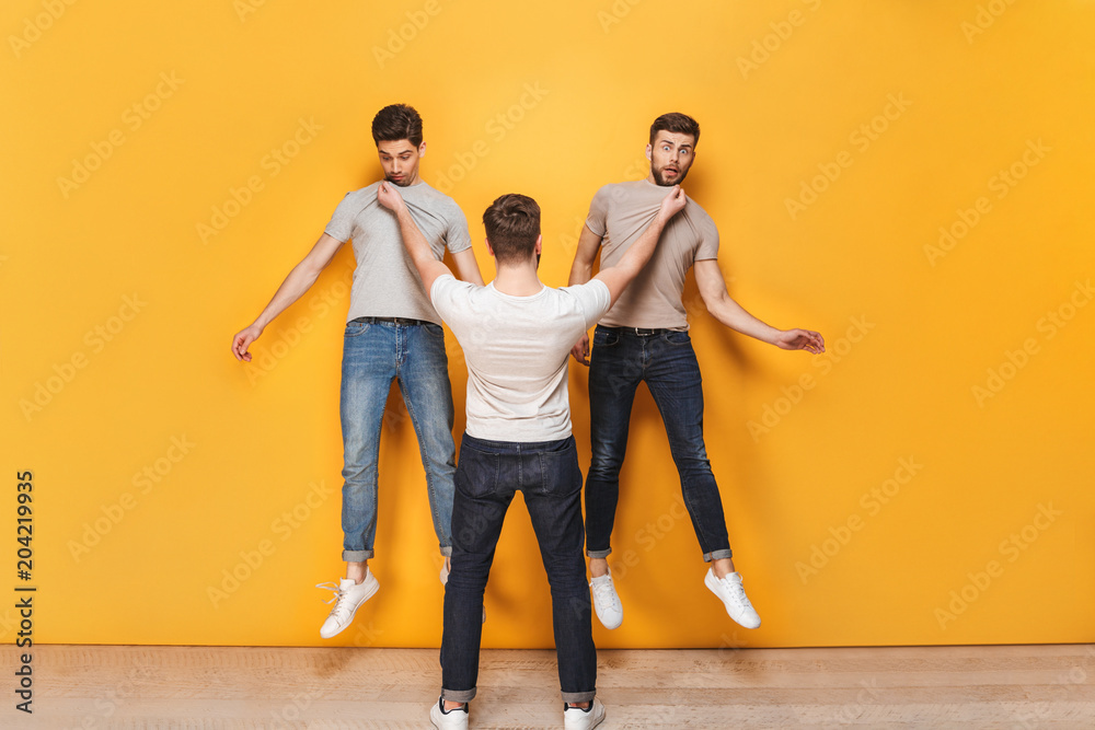 Angry man holding two other men by the collar Stock Photo | Adobe Stock