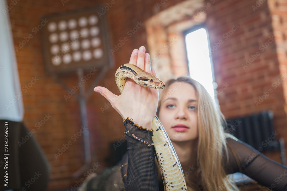 Elegant blonde woman lying on the bed with python Stock Photo | Adobe Stock