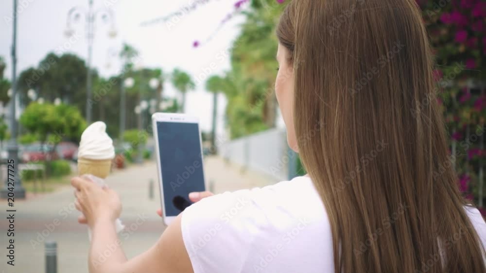 Young Woman Taking Photo Of Ice Cream Cone Outdoors In Summer Happy