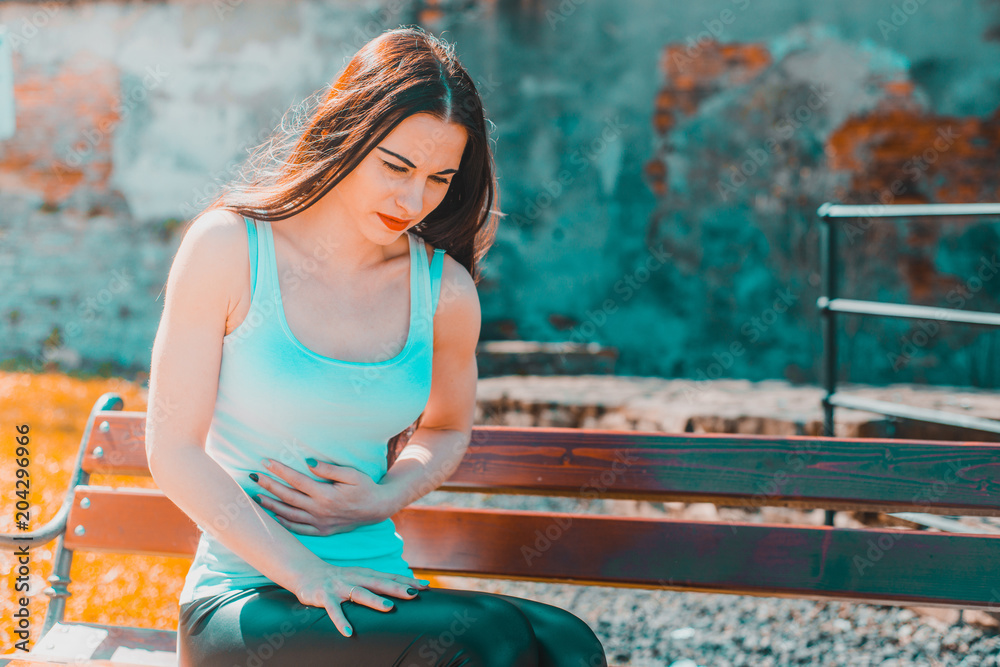 The woman is holding her belly. The girl is suffering, her stomach ...