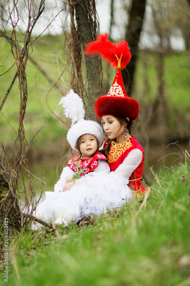 Kazakh people in national costumes. Woman and daughter in the park ...