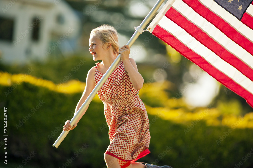 Girl carrying American flag while running through her backyard Stock ...