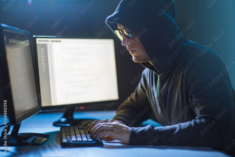 cybercrime, hacking and technology concept - male hacker in dark room ...