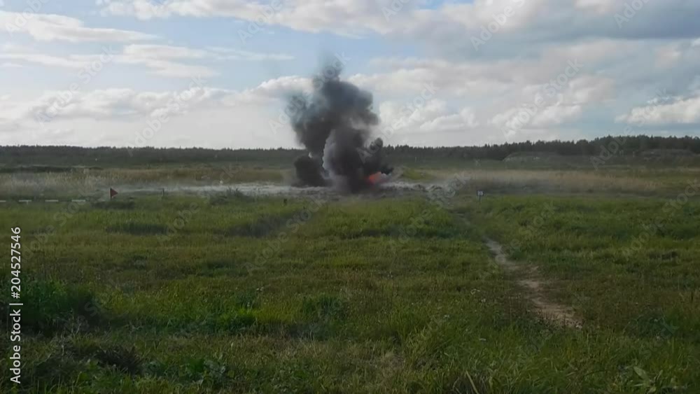 Stunt girl in a fiery explosion. Beautiful girl stunt runs across the ...