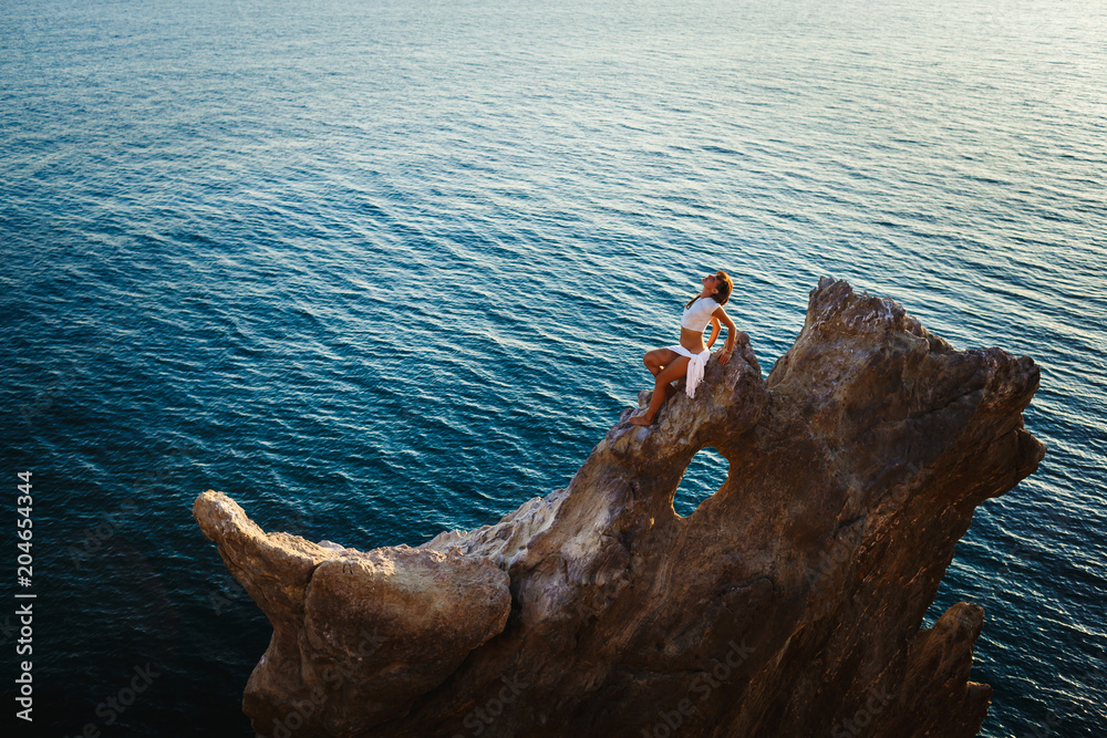 A high cliff in the form of a natural bed is high above the sea. The ...