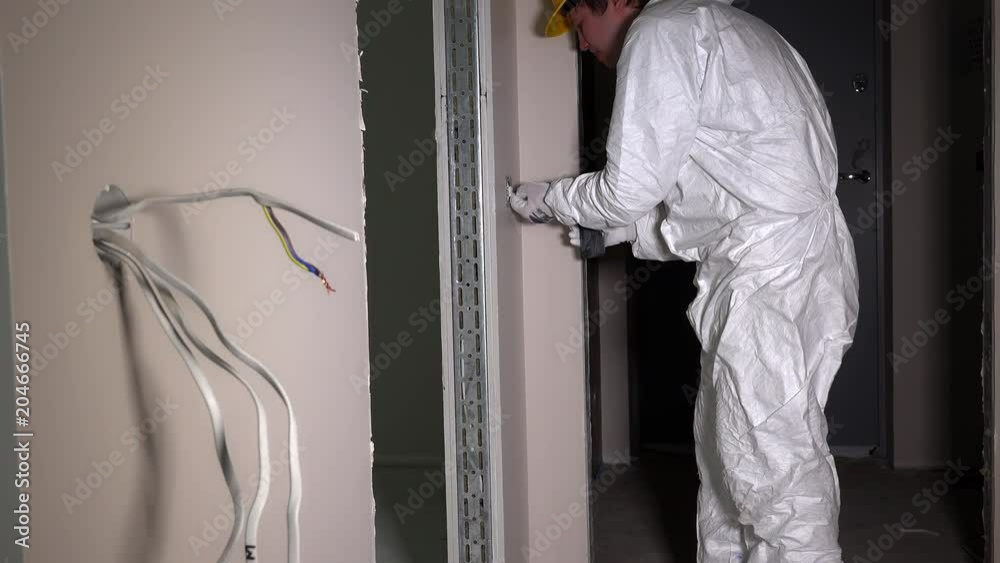 Electrician screw light switch with electrical drill. Man in work wear ...