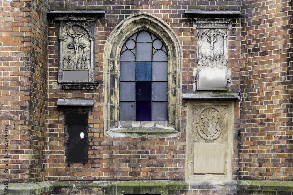 Detail of a brick cathedral in the Gothic style. Carved bas-reliefs on ...