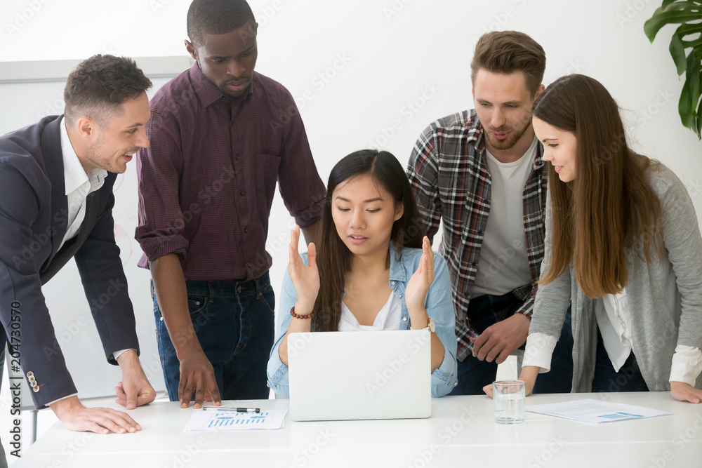 Serious multiracial millennial team solving online problem together ...